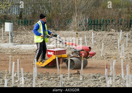 man operating a machine to level ground on a construction site in the ...
