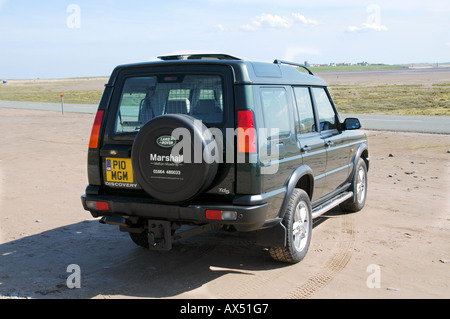 Rear view of a Land Rover Discovery climbing a steep off-road slope ...