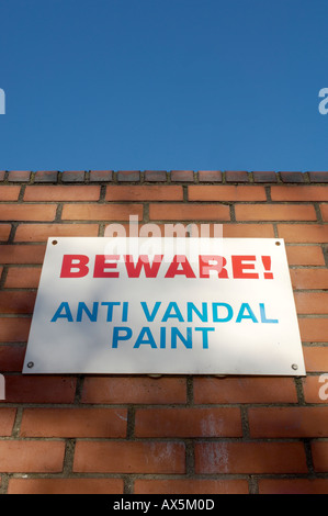Beware Anti Vandal Paint sign mounted on a brick wall seen against a ...