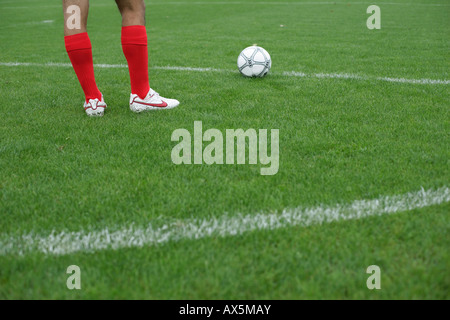 Rear view of soccer player preparing to kick a ball towards the goal ...