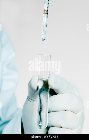 Chemist filling substance into a test tube with pipette Stock Photo - Alamy