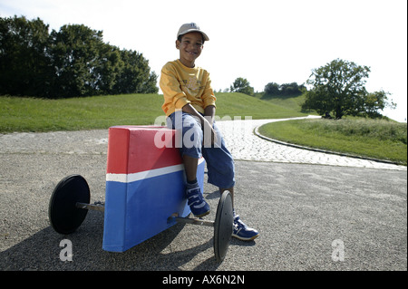 Portrait of boy sitting on soapbox and smiling Stock Photo - Alamy