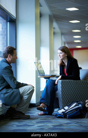 Side profile of a professor and two college students smiling in a ...