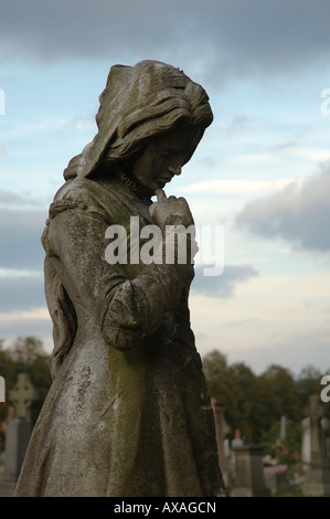 statue of sad woman looking down with reclined head and hands together ...
