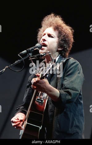 Folk rock star Bob Dylan singing at microphone and playing guitar ...