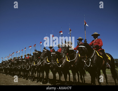 Mountie in red ceremonial uniform on black RCMP horse on the lawn in ...
