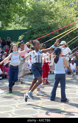 Primary school fete celebrating May day dancing around the maypole ...