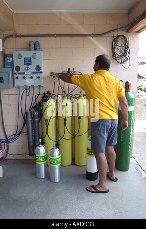 A staff member MR fills a nitrox tank at a nitrox blending fill station ...