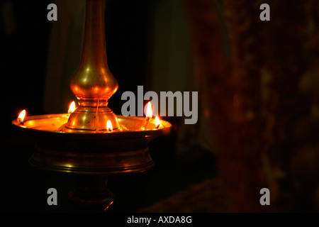 Traditional brass Kerala lamp known as nilavilakku or vilakku lights up ...