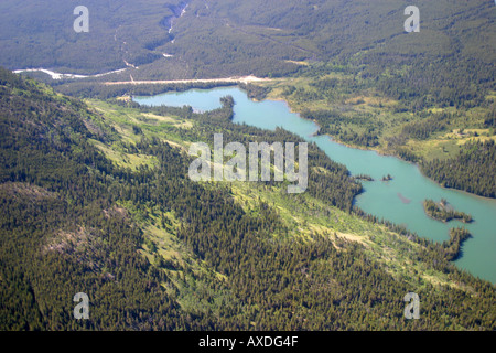 Aerial view of the forests surrounding a vivid blue lake in British ...