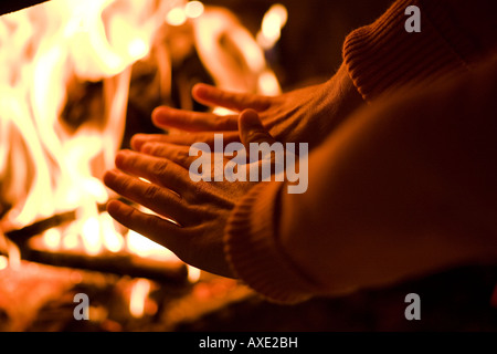 Person warming their hands over a fire Stock Photo - Alamy