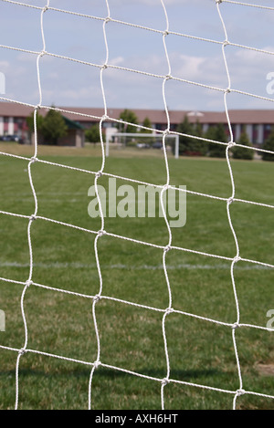 Soccer net background, view from behind the goal with blurred field ...