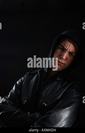 Violent teenage hooligan in a hoodie and hardhat brandishing a wooden ...
