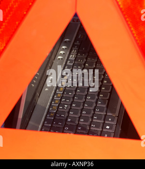 Laptop keyboard through a hazard warning triangle Stock Photo - Alamy