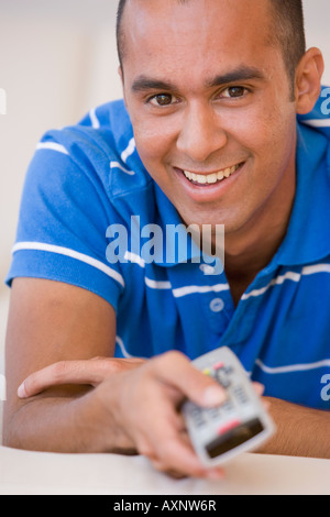 Young man pointing remote control Stock Photo - Alamy