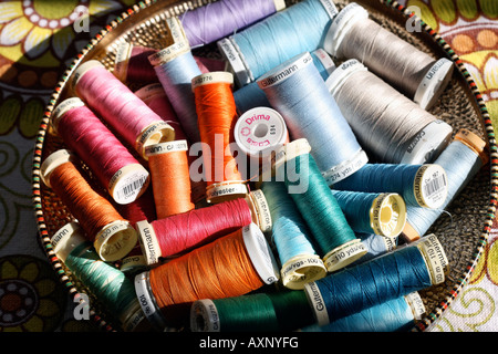 Colorful cotton thread reels and fabric flowers isolated on white ...