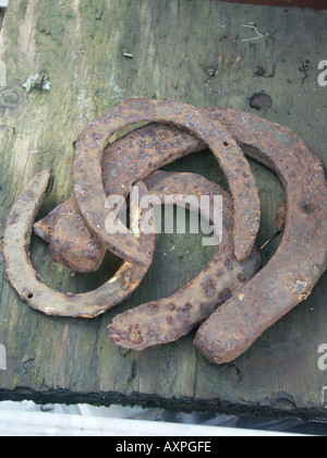 four old rusty horseshoes on wooden background. horseshoes as good luck ...
