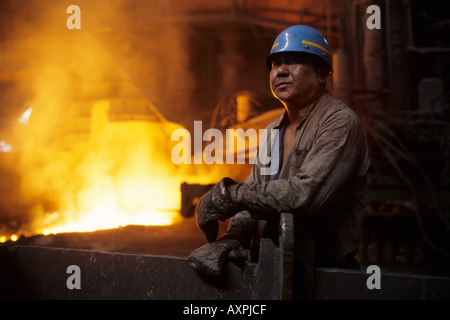 A steel worker in front of a blast furnace in Benxi Iron and Steel ...