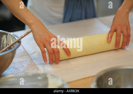 Pastry chef rolling up swiss roll Stock Photo - Alamy