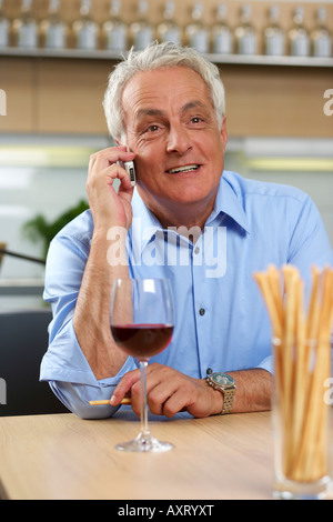 Smiling short-haired man with glass of red wine in one hand Stock Photo ...