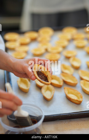 Filling pastry boats with chocolate Stock Photo - Alamy