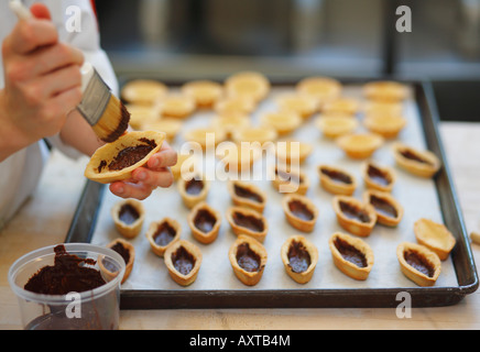 Filling pastry boats with chocolate Stock Photo - Alamy