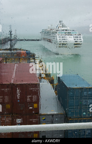 A cruise ship departs port in rain as viewed through a rain splashed ...