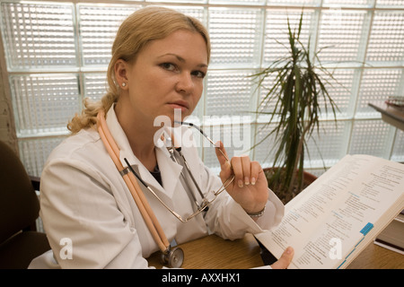Female doctor reading a textbook in medical office; light effect Stock ...