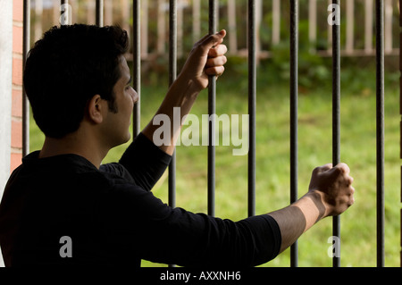 Single male prisoner behind bars in jail cell, USA Stock Photo - Alamy