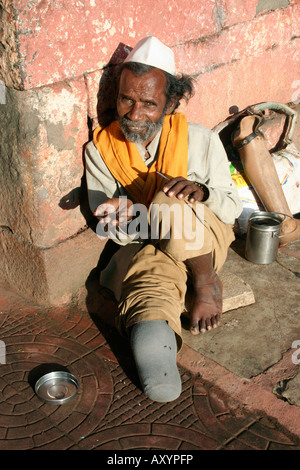 Man with one leg begging in the street. There are many beggars in and ...