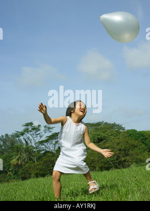Girl reaching for a balloon Stock Photo - Alamy