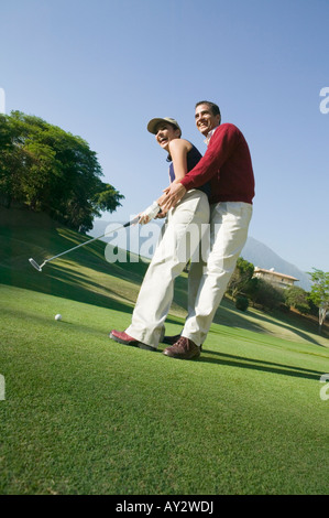 Mature couple laughing while playing golf Stock Photo - Alamy