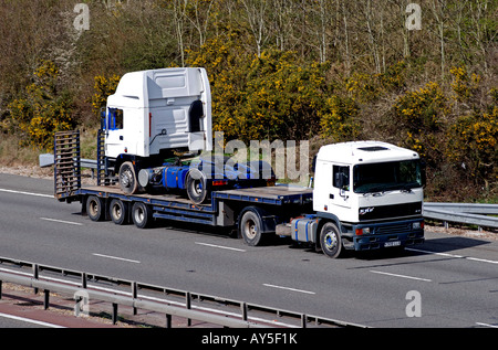 A low-loader articulated lorry carrying a digger, M40 motorway ...