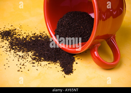 Ground coffee spilling out of red cup Stock Photo - Alamy