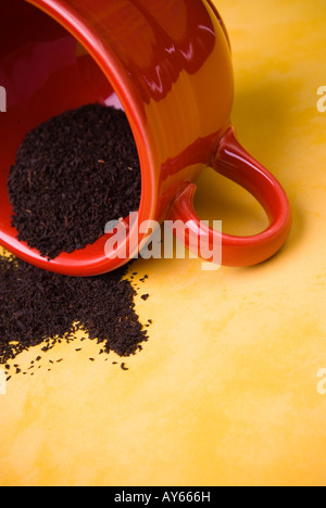 Ground coffee spilling out of red cup Stock Photo - Alamy