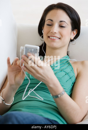 Young woman listening to MP3 player Stock Photo - Alamy