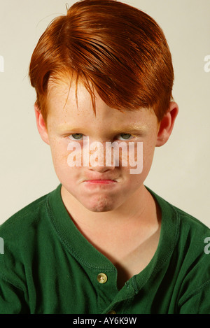 An angry 5 year old red headed Caucasian boy in a green shirt from ...