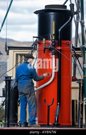 A man painting the funnel of an old steam puffer boat Scotland Stock ...