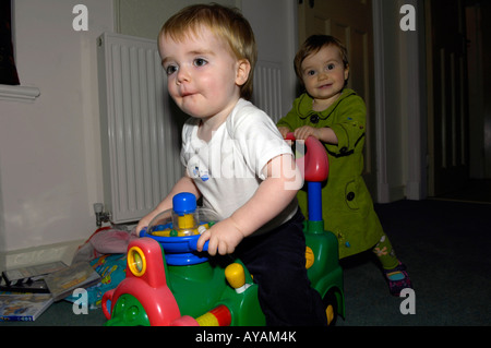 cousins boy girl toddlers one and two year old babies fun play together family Stock Photo - Alamy