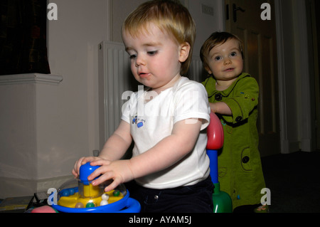 cousins boy girl toddlers one and two year old babies fun play together family Stock Photo - Alamy