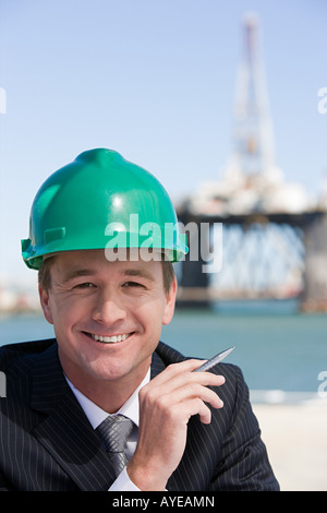engineer holding white helmet with construction crane background Stock ...