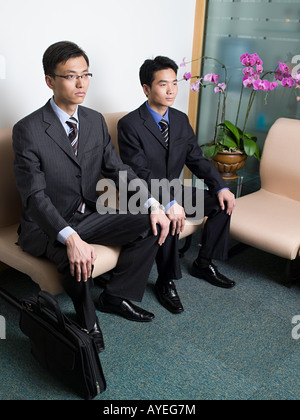 Serious young businessman waiting with his luggage Stock Photo - Alamy
