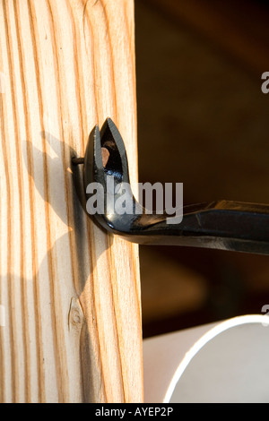 A cats paw crowbar pulling a nail out of a piece of wood Stock Photo ...