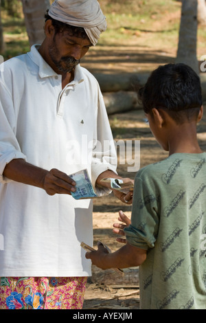 India, Kerala, money, Indian man holding up 1000 rupee note to light to ...