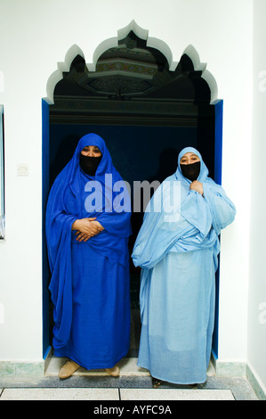 Muslim women wearing the traditional chador walk past the ramparts that ...