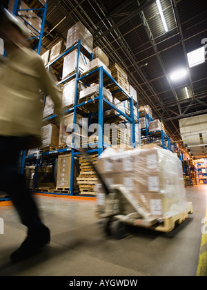 Warehouse worker pulling a hand truck loaded with burlap sacks isolated ...