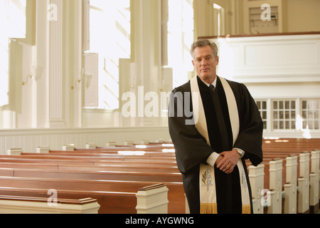 Priest standing next to pews Stock Photo - Alamy