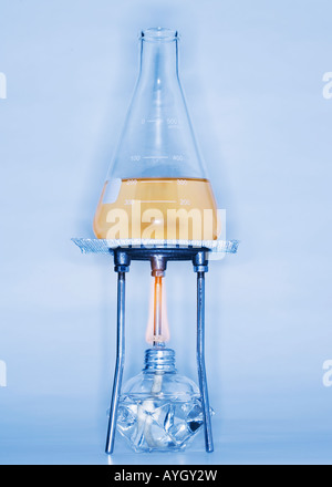 Glass laboratory beaker on Bunsen tripod with thermometer showing water ...