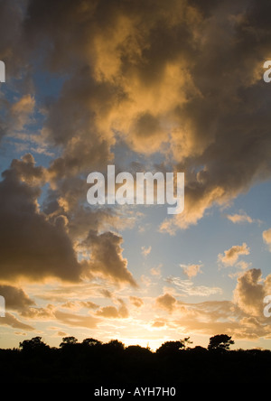 Setting sun beaming through dramatic clouds between 2 mountains Stock ...