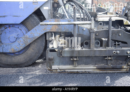 construction workers and surfacing machine laying road surface for the ...